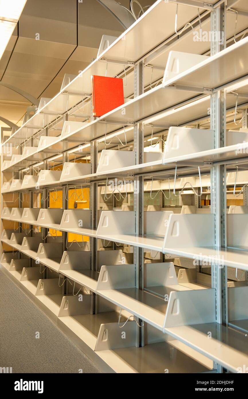 Empty library shelves with one red book Stock Photo - Alamy