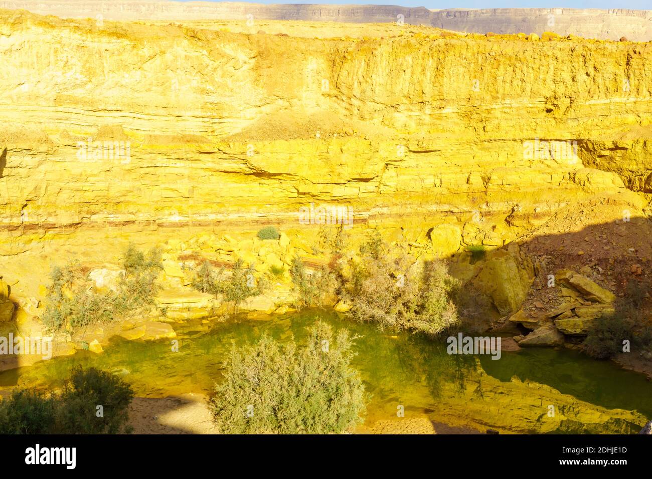View of a water hole and layered rock formation, along the Ramon Colors ...