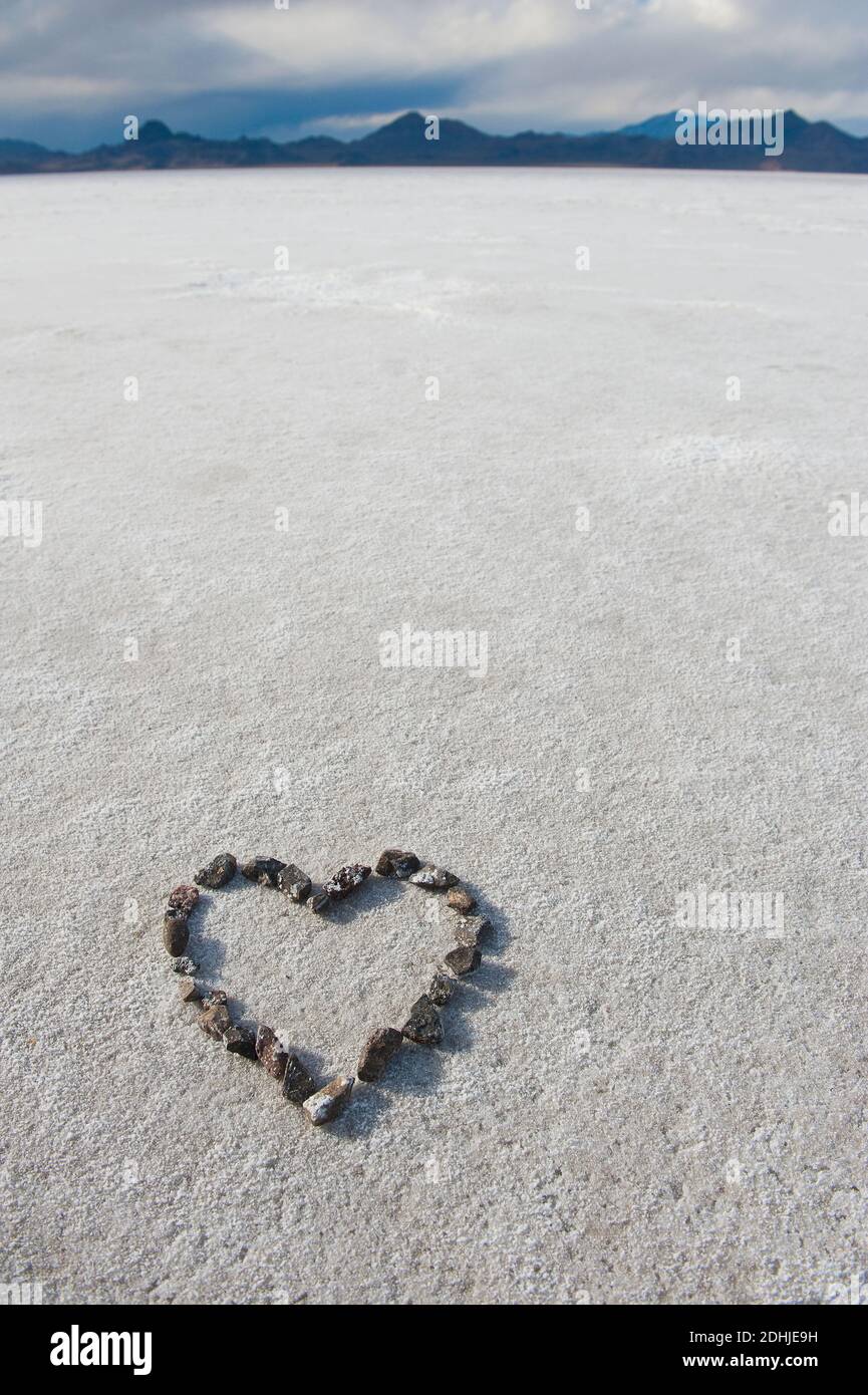Pebbles arranged on salt flat in the shape of a heart Stock Photo - Alamy