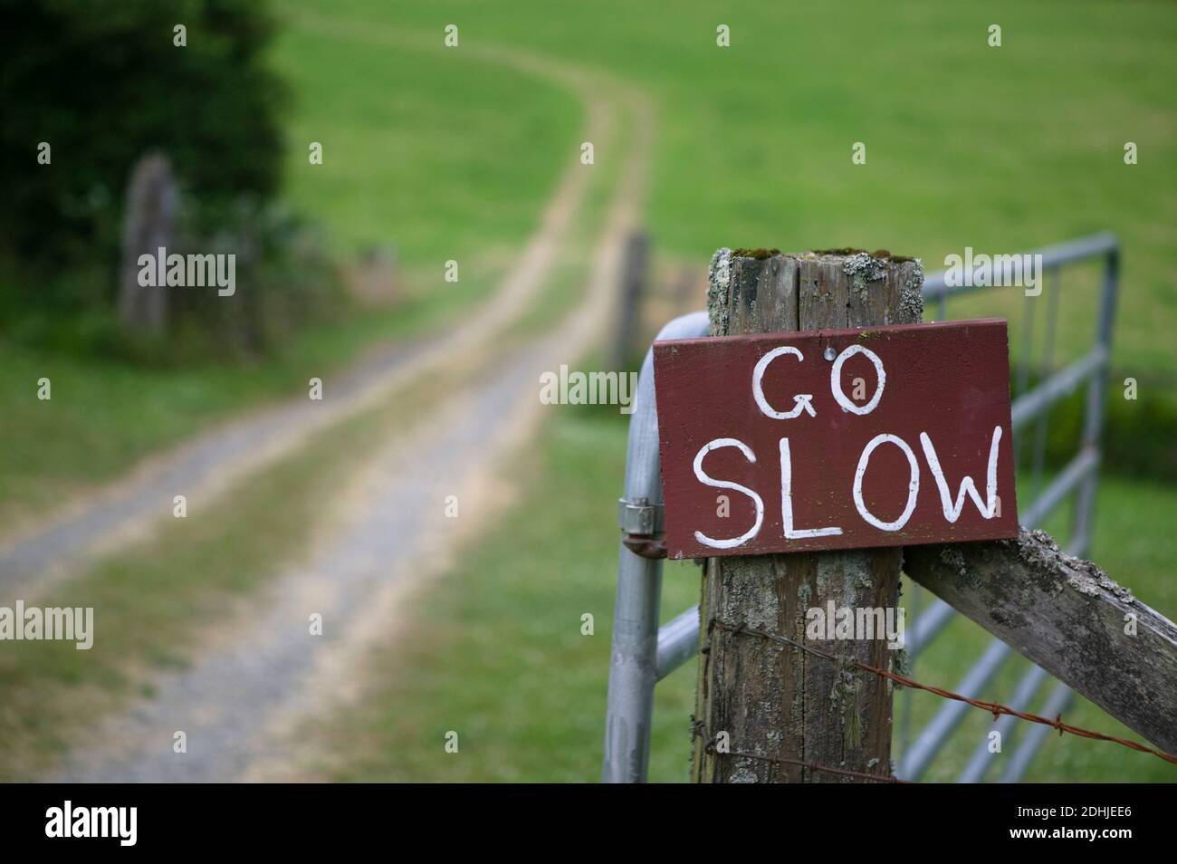 Go slow sign on wooden countryside gate Stock Photo - Alamy