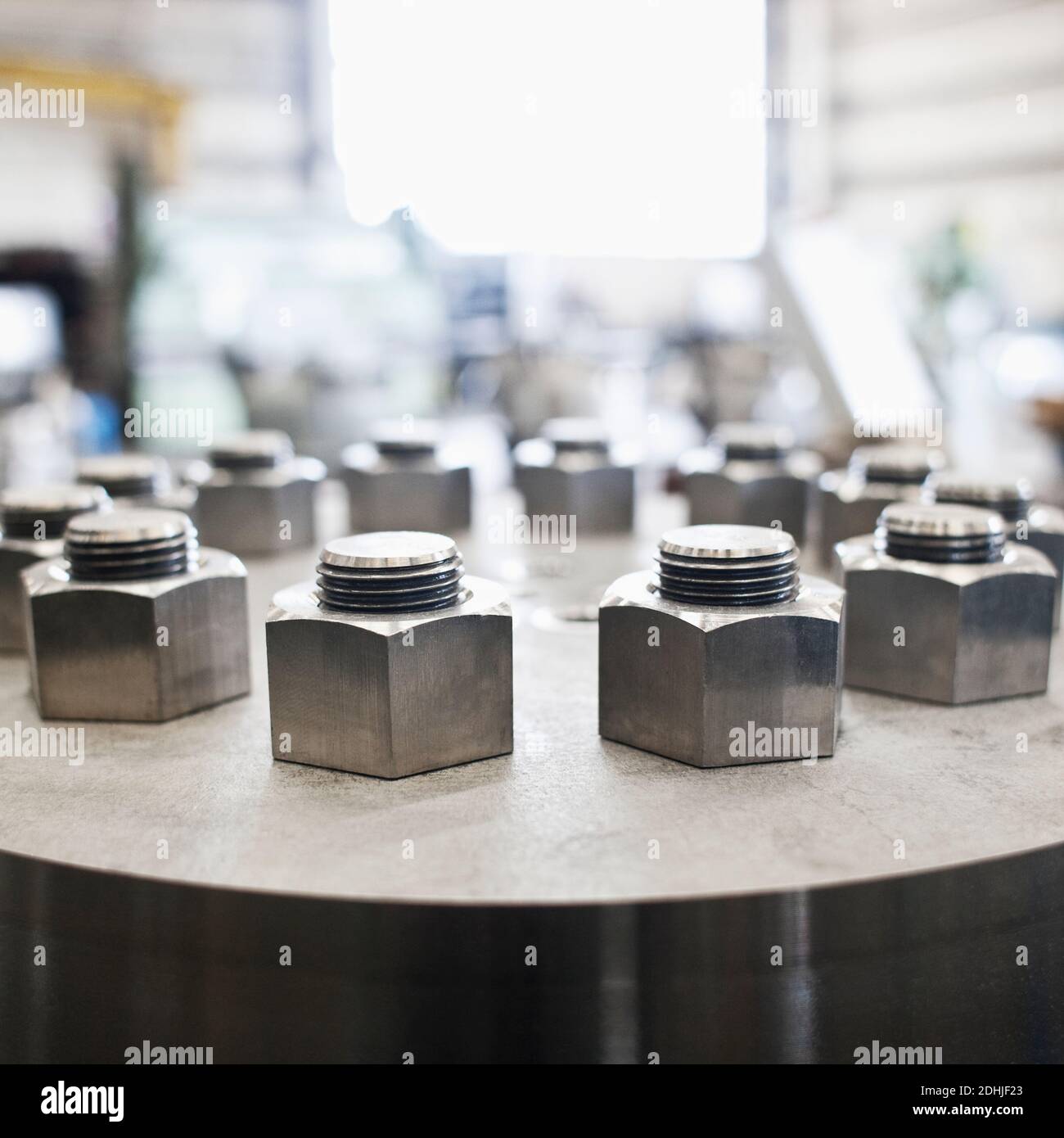 Nuts and bolts on cylinder in workshop Stock Photo - Alamy