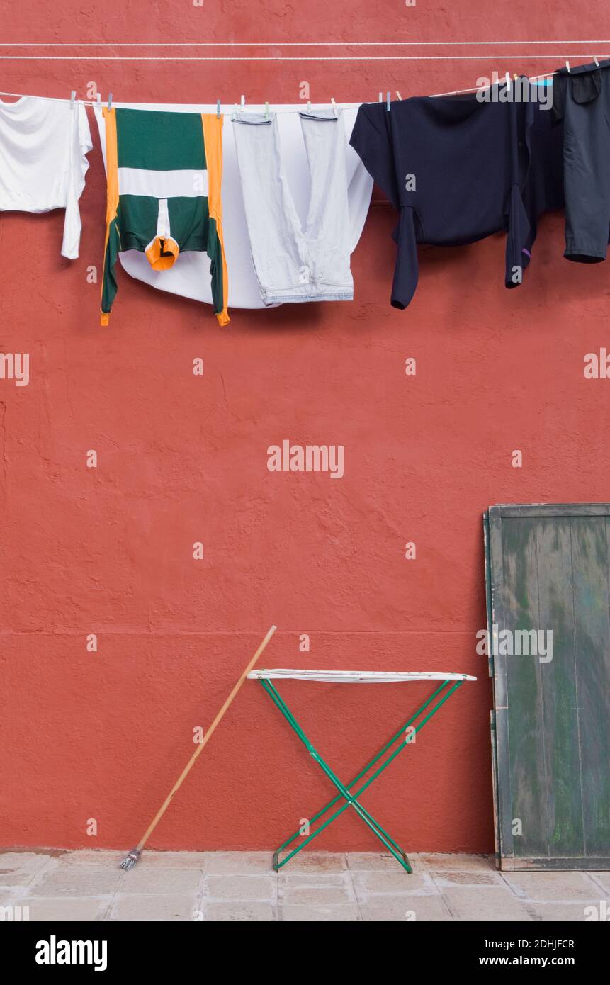 Clothes hanging on laundry line on wall Stock Photo - Alamy