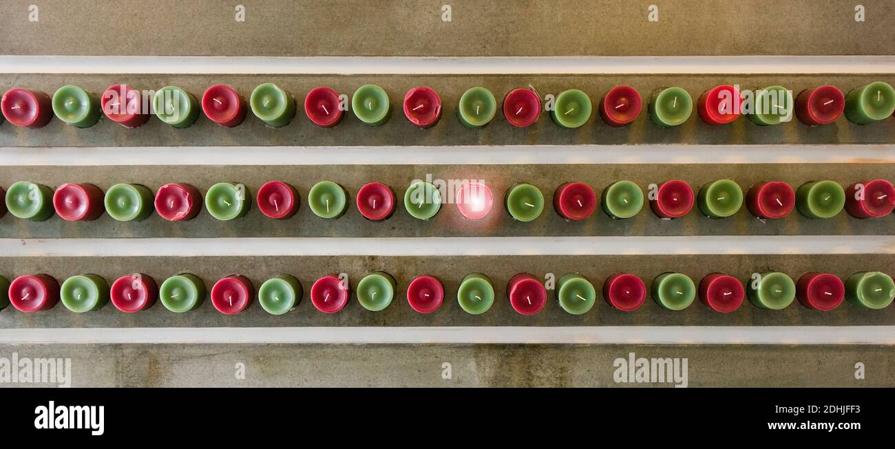 Overhead view of red and green candles lined up, one lit Stock Photo ...