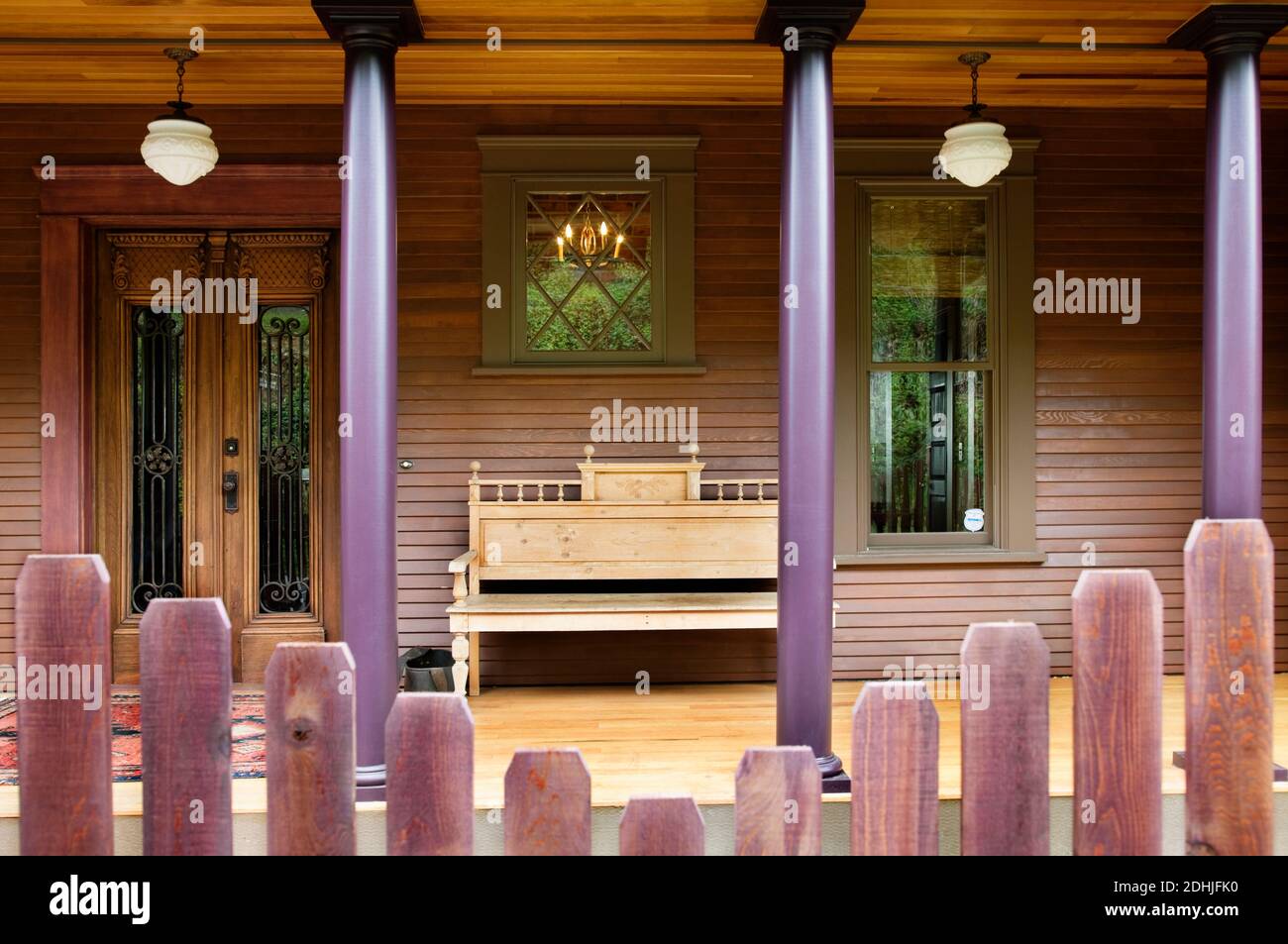 Wooden fence and house porch with columns and bench Stock Photo - Alamy