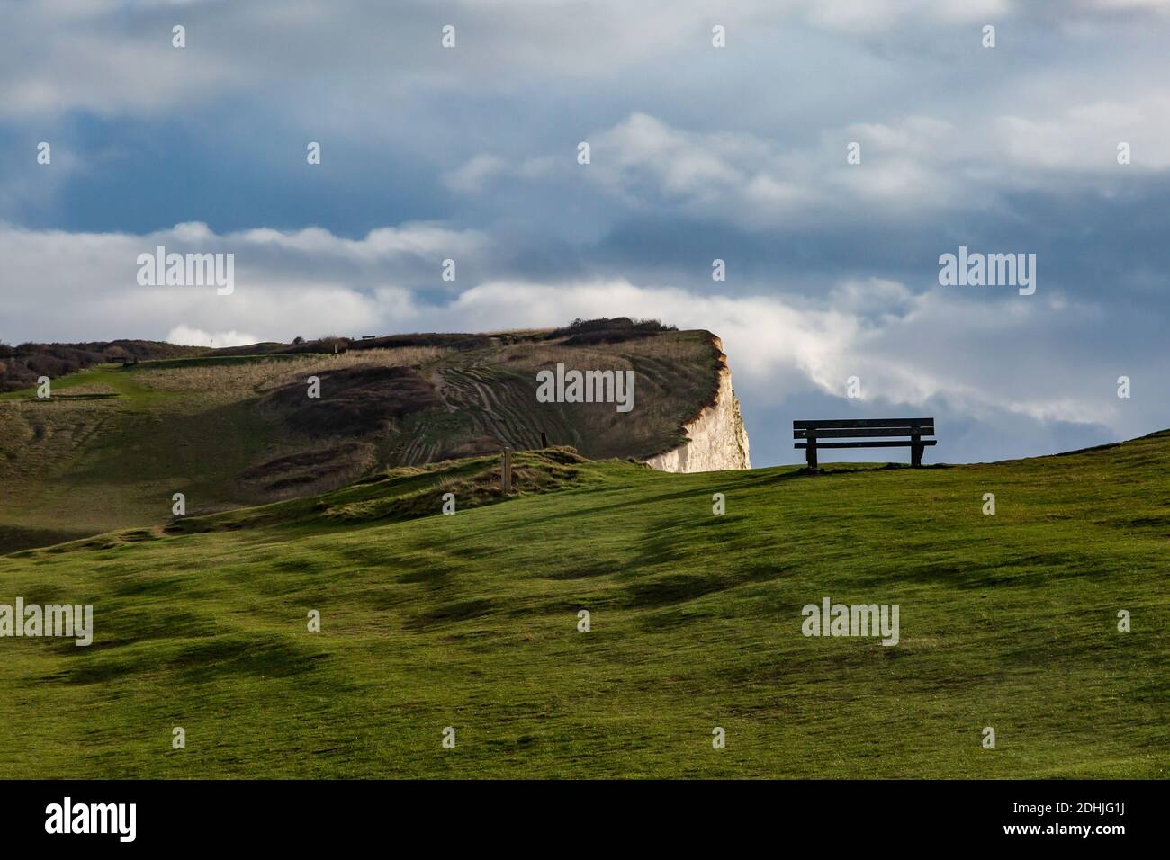 A bench on the Sussex coast with a view out over chalk cliffs Stock ...