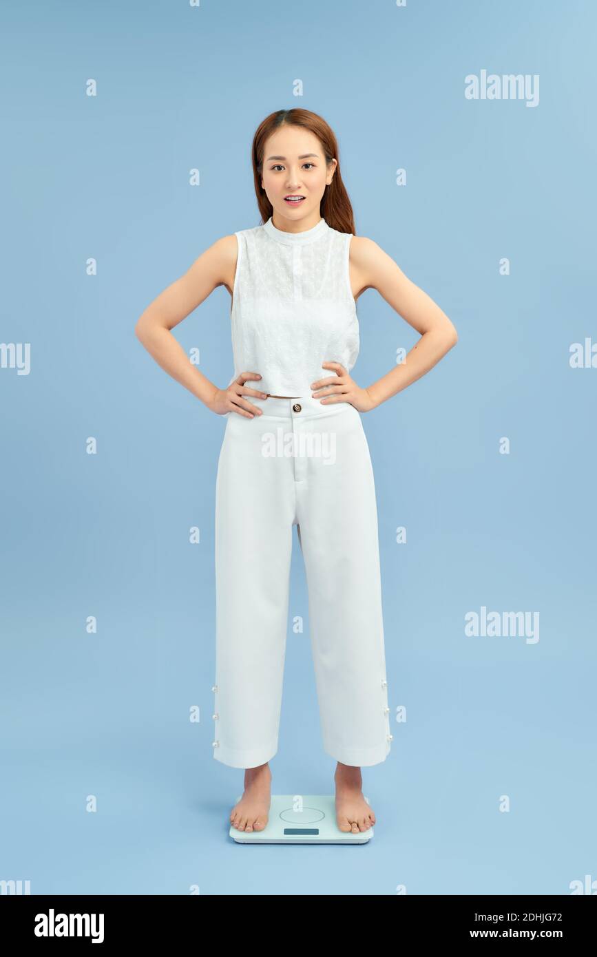 Portrait of a gorgeous young woman standing on a scale Stock Photo - Alamy