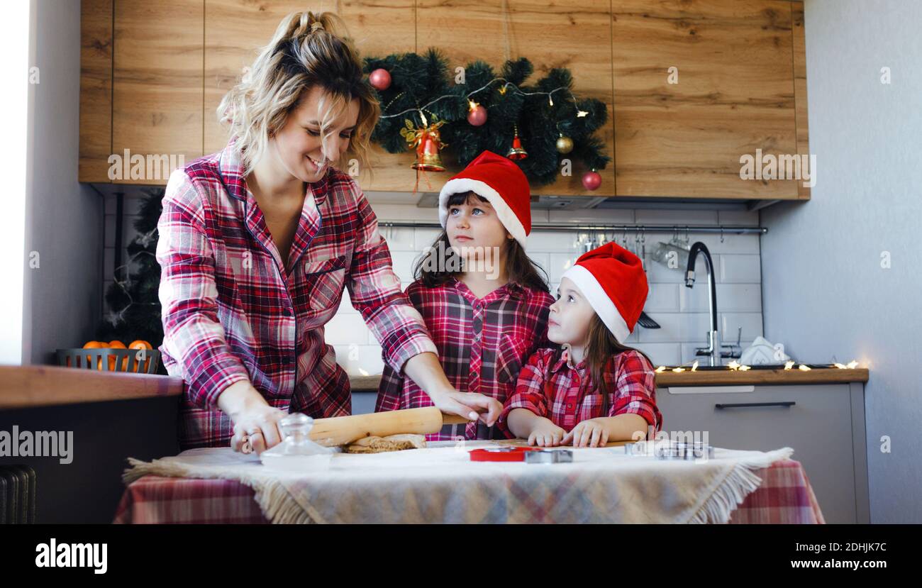 mom teaches her daughters in the kitchen to make a delicious dessert ...
