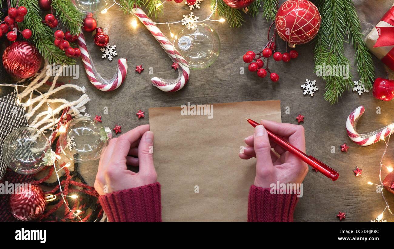 Female hands write letter with red pen to Santa Claus among Christmas ...