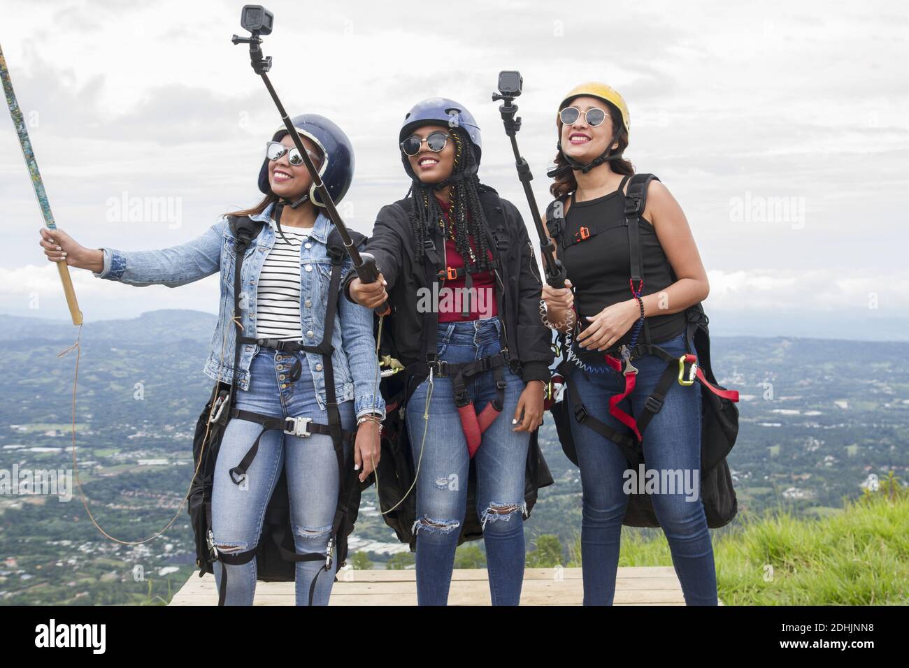 three hispanic beautiful young women outdoors taking selfie with action ...