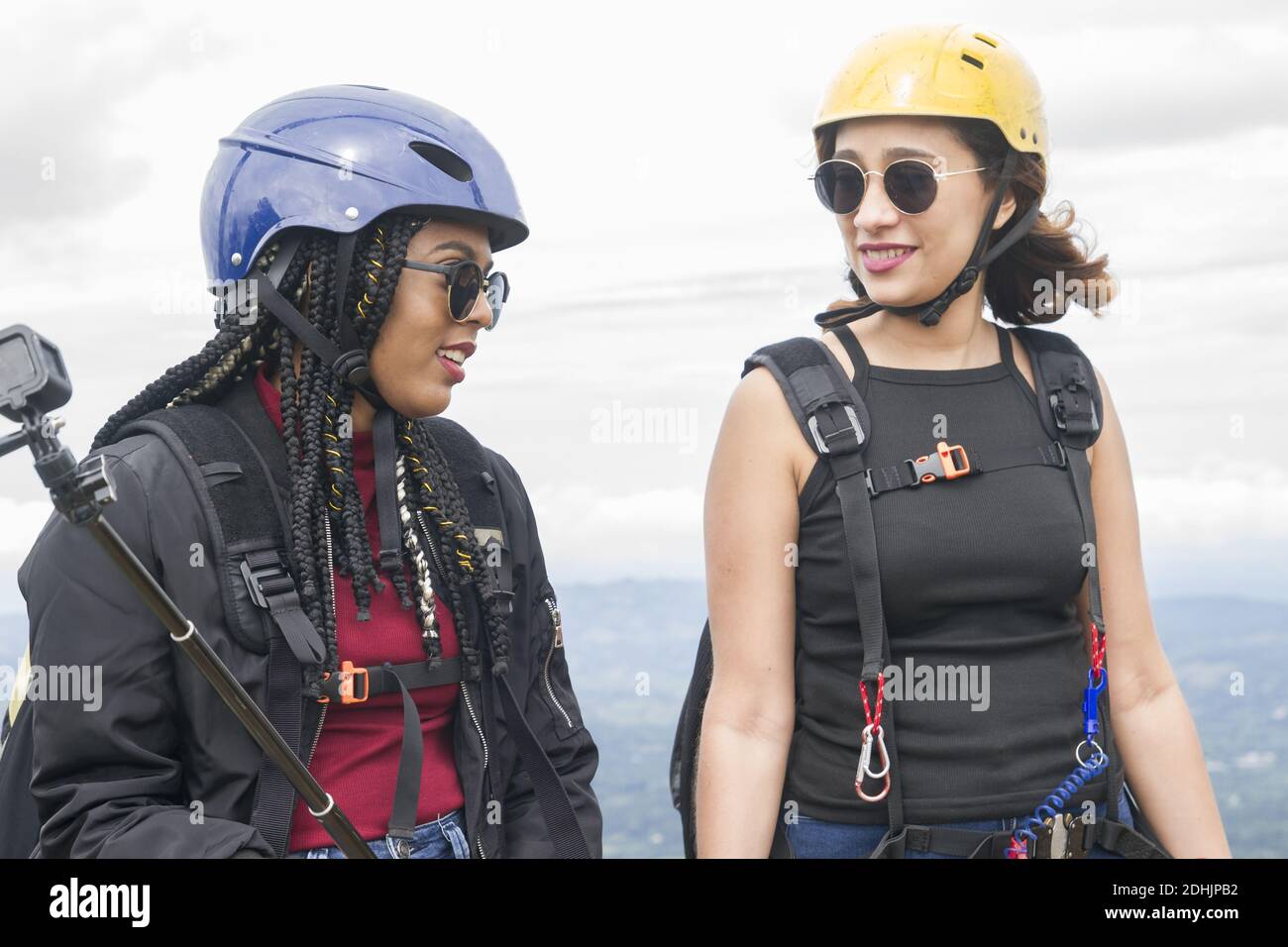 two hispanic beautiful young women outdoors talking and wearing ...