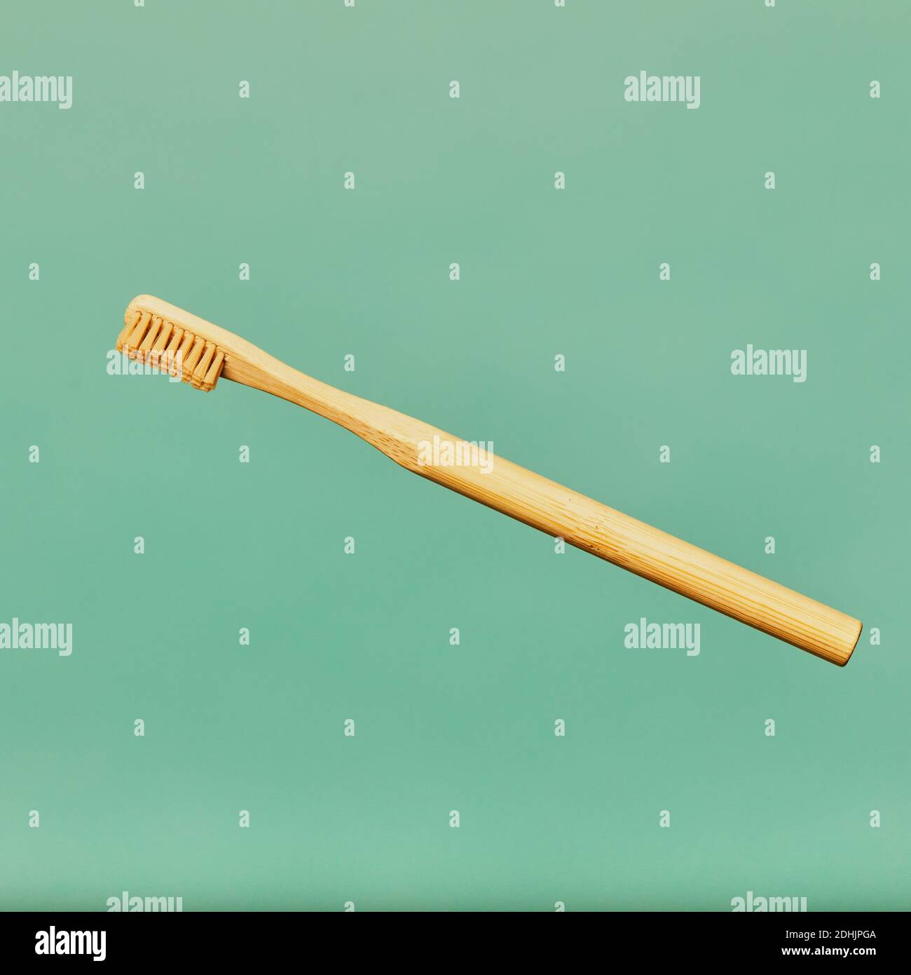 Toothbrush made of bamboo on blue background in studio showing concept ...