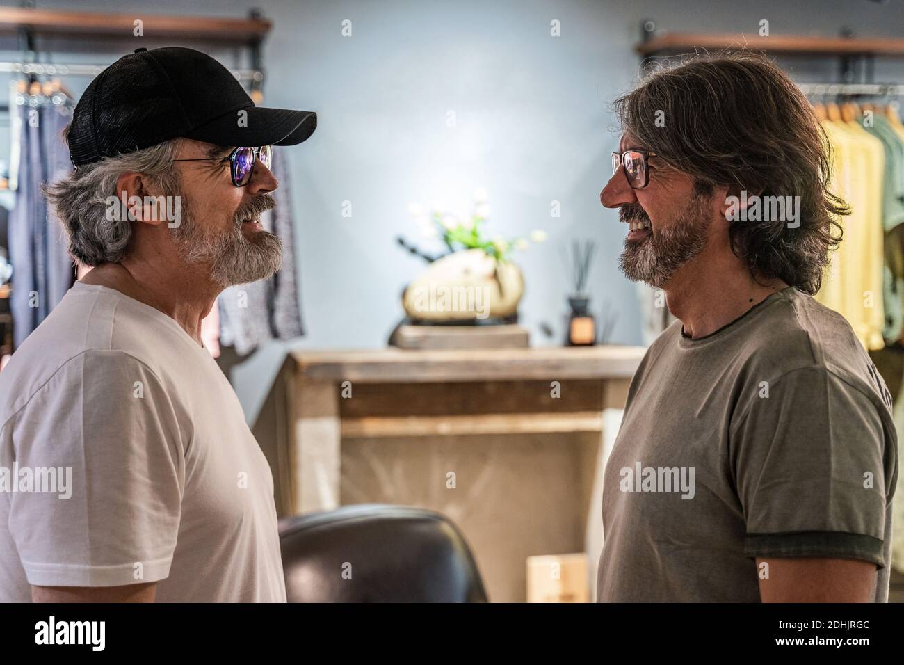 Side view of clothing store owner and customer talking face to face ...