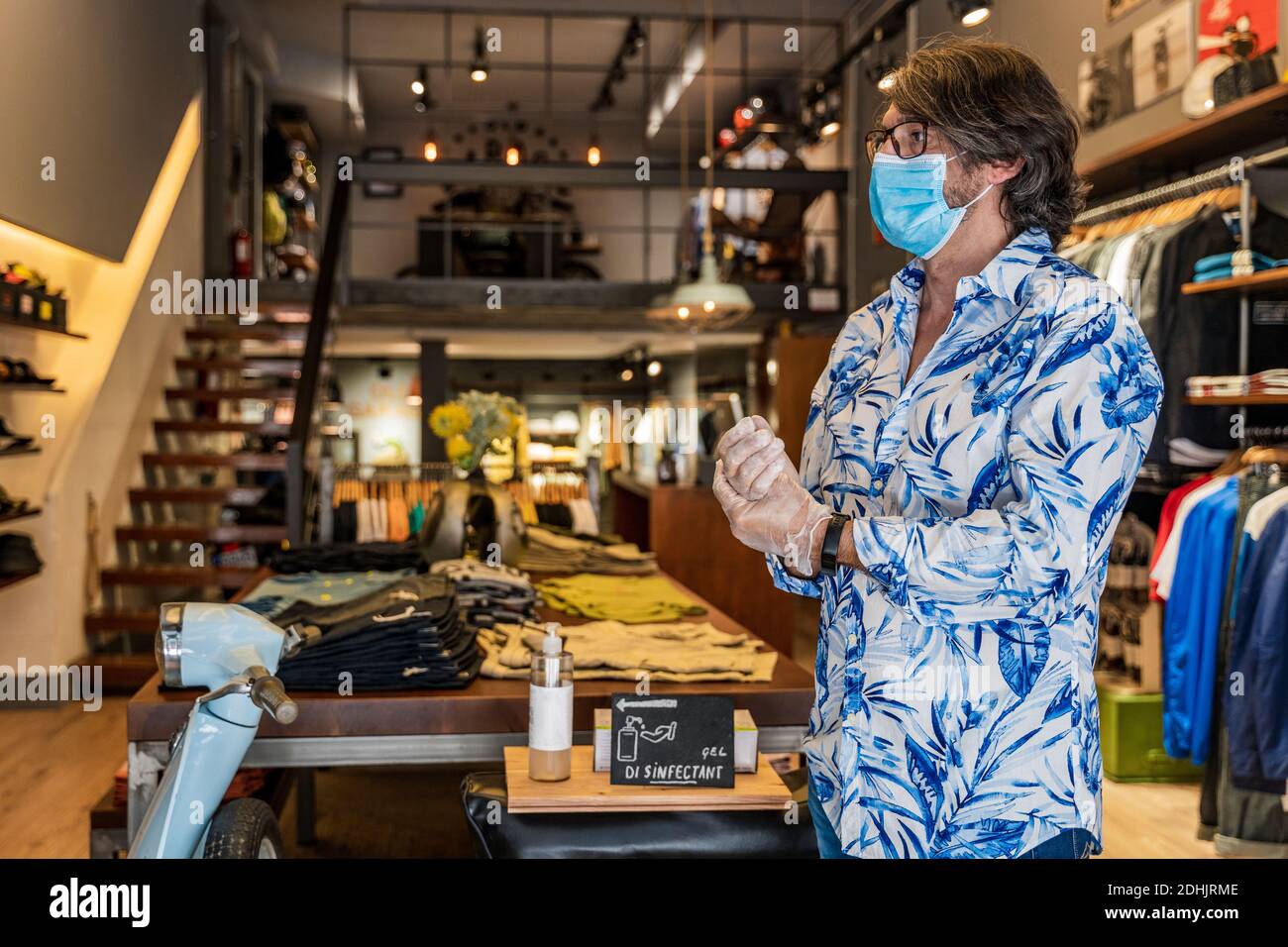 Side view of Customer with face mask and gloves shopping in a clothing ...