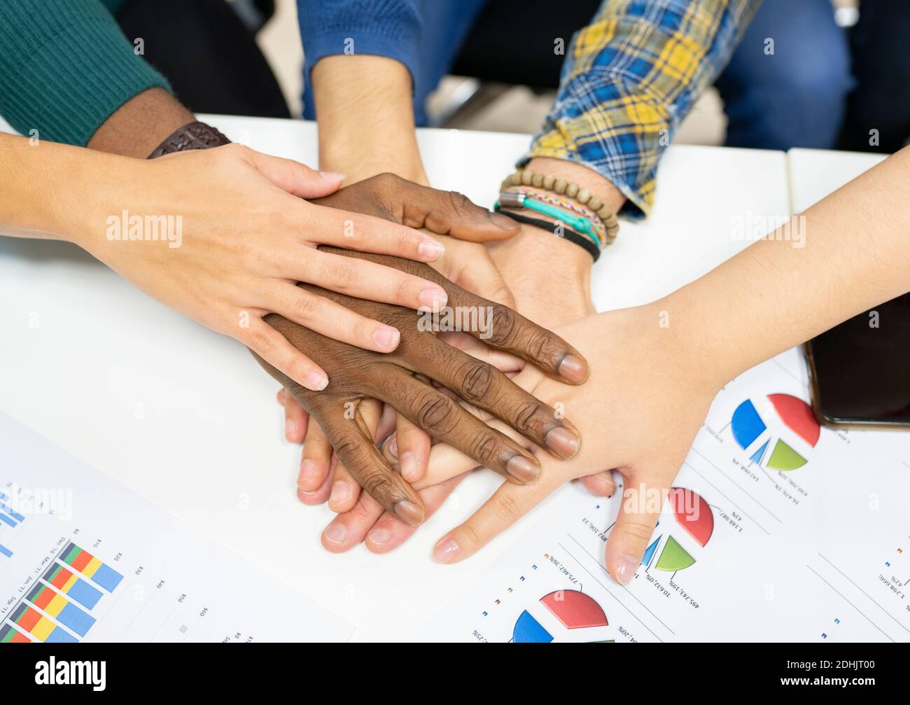 From above of crop anonymous multiracial colleagues in casual clothes ...