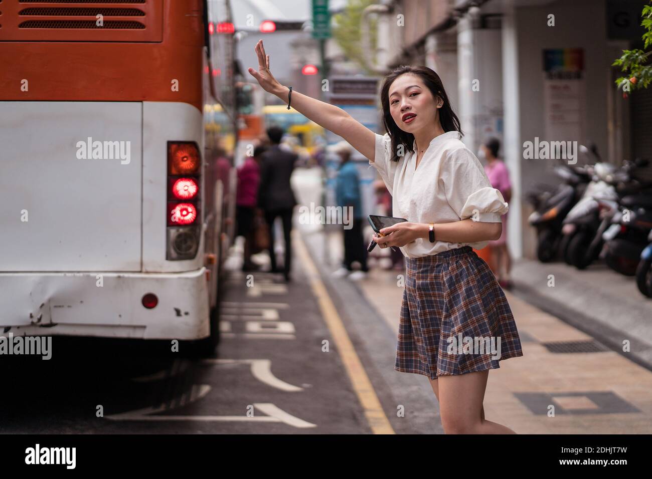 Side view of self assure young Asian lady with long hair in fashionable ...