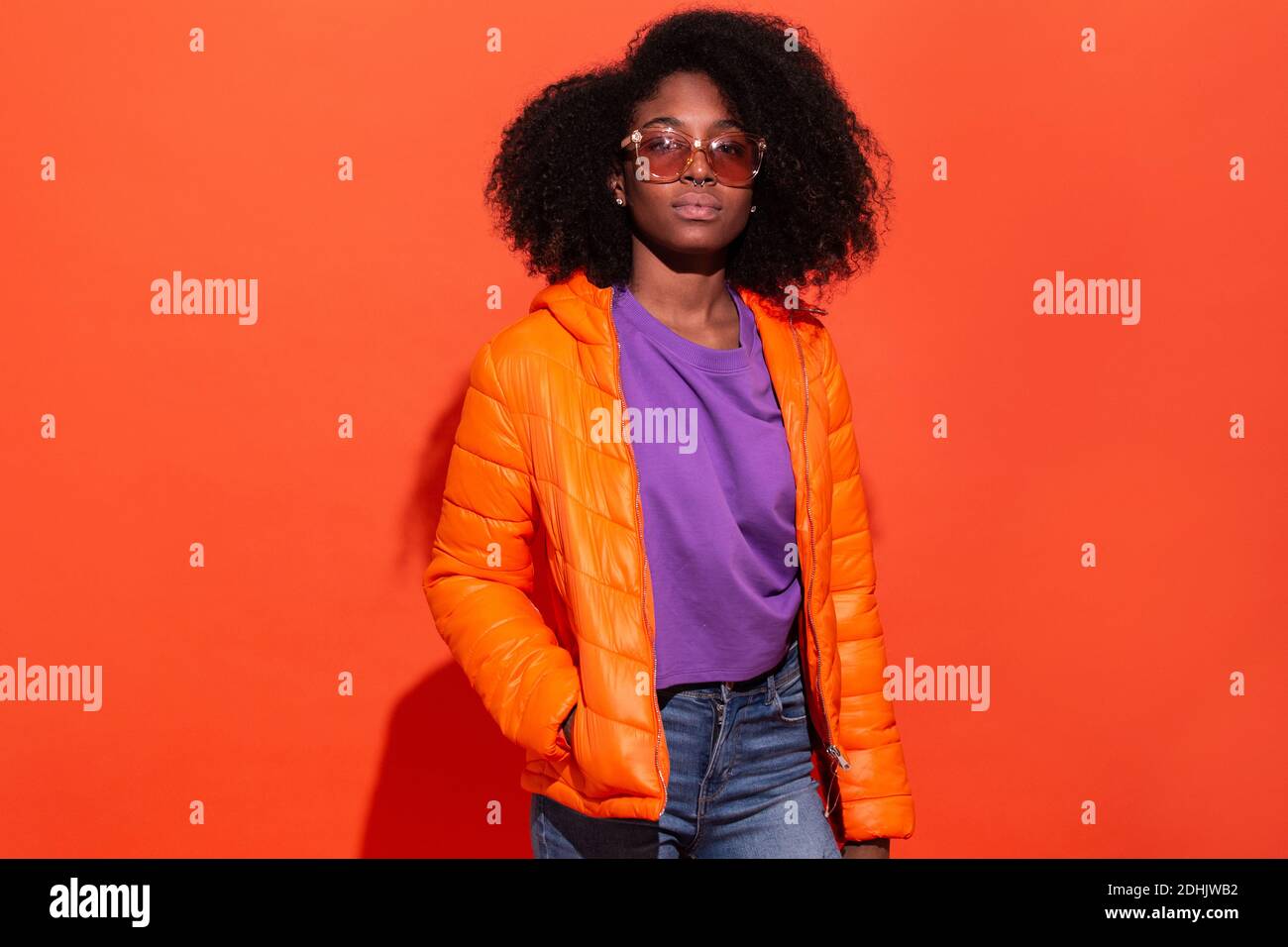 Cheerful eccentric female with dyed hair looking at camera and doing ...
