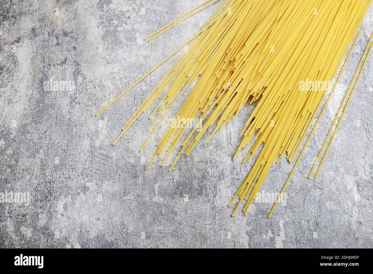 Mixed types and shapes of italian pasta on grey stone, background. Copy ...