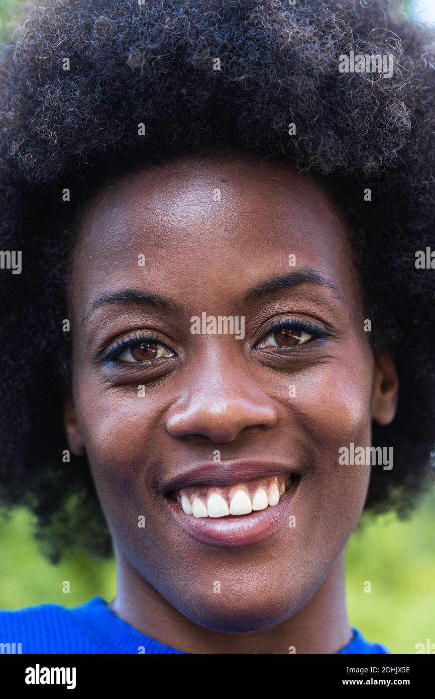 Cheerful black female with Afro hairstyle and charming toothy smile ...
