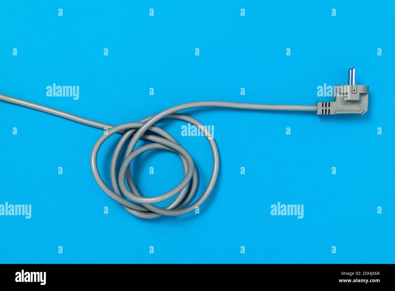 Electric cable with plug on a blue background Stock Photo - Alamy