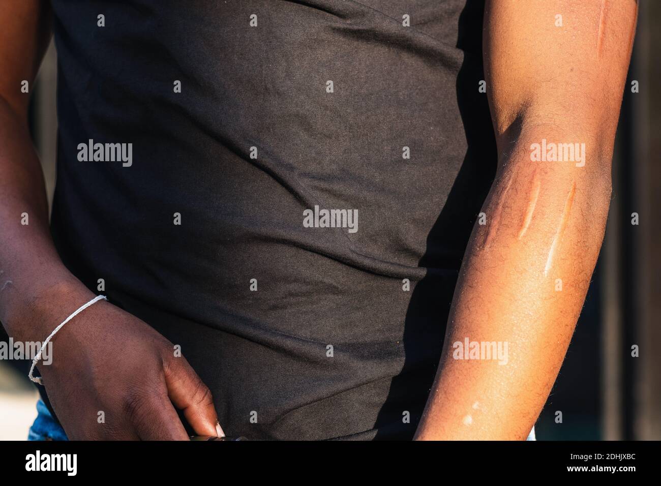 Crop unrecognizable person in black top with arm covered with long ...