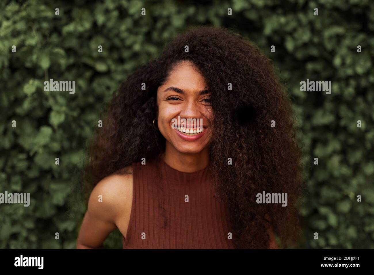 Side view of young female surfer in wetsuit on waving seawater with ...