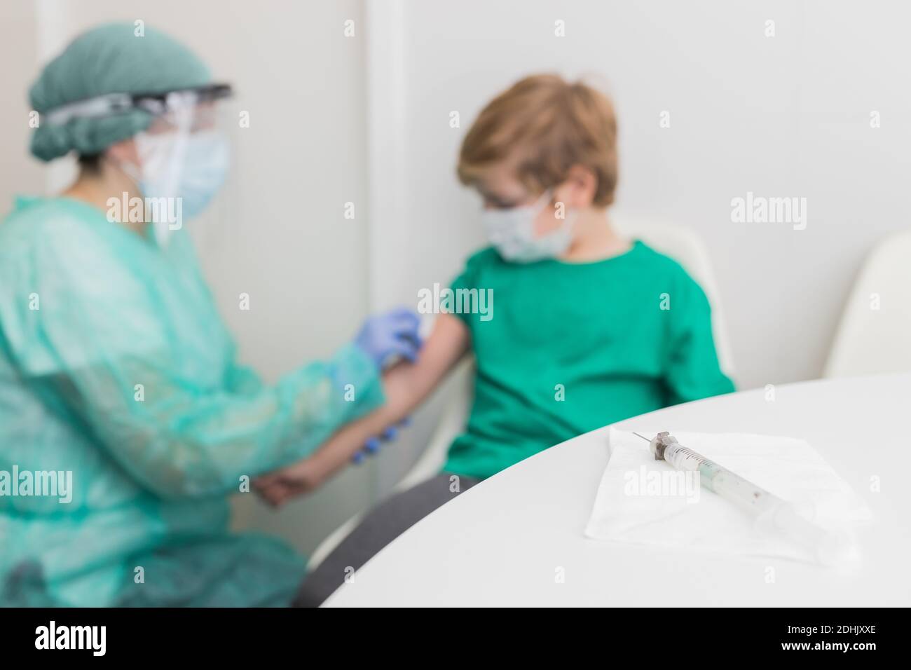 Side view of medic in protective costume disinfecting skin of patient ...