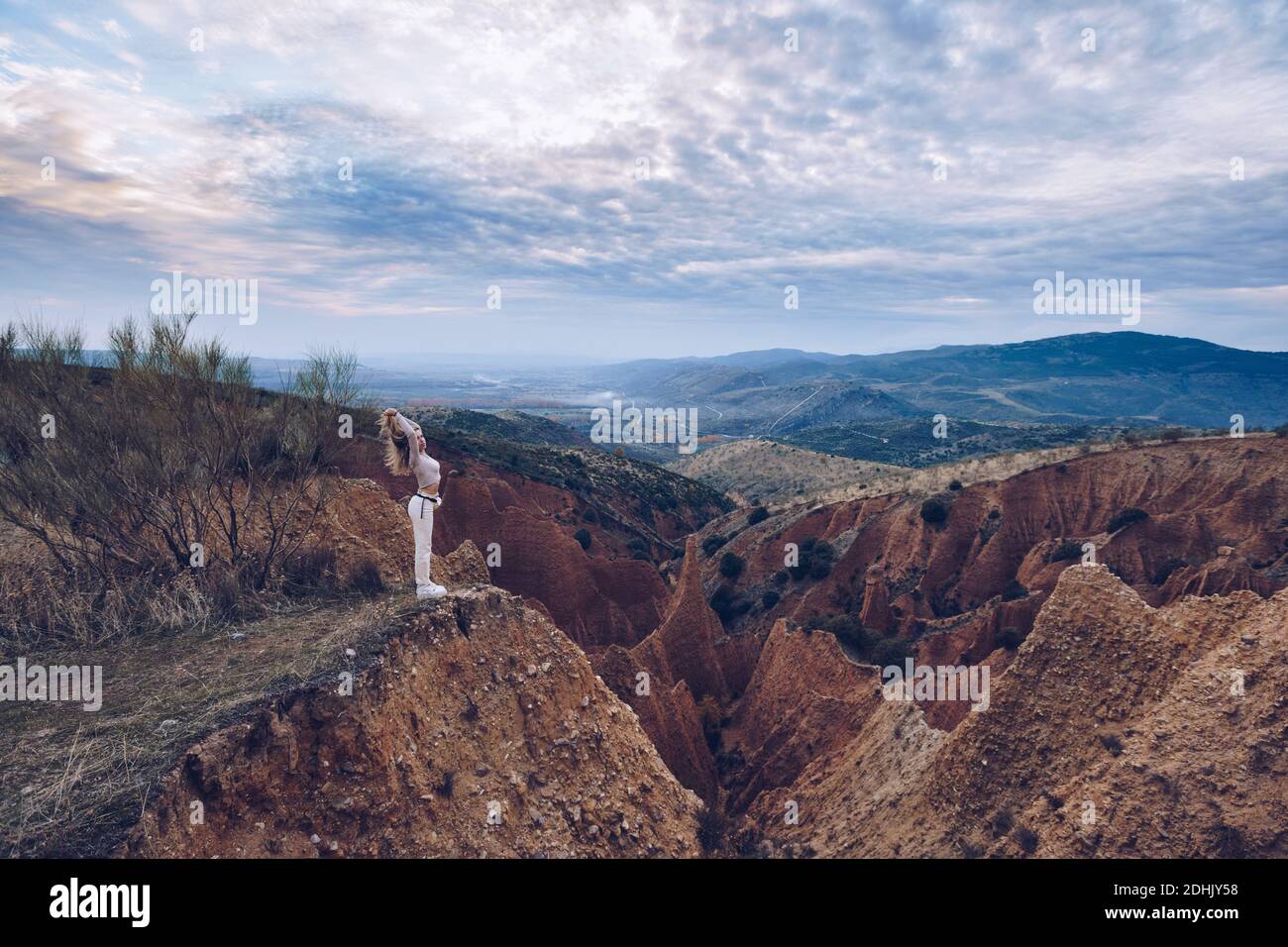 From above side view of unrecognizable female explorer standing on edge ...