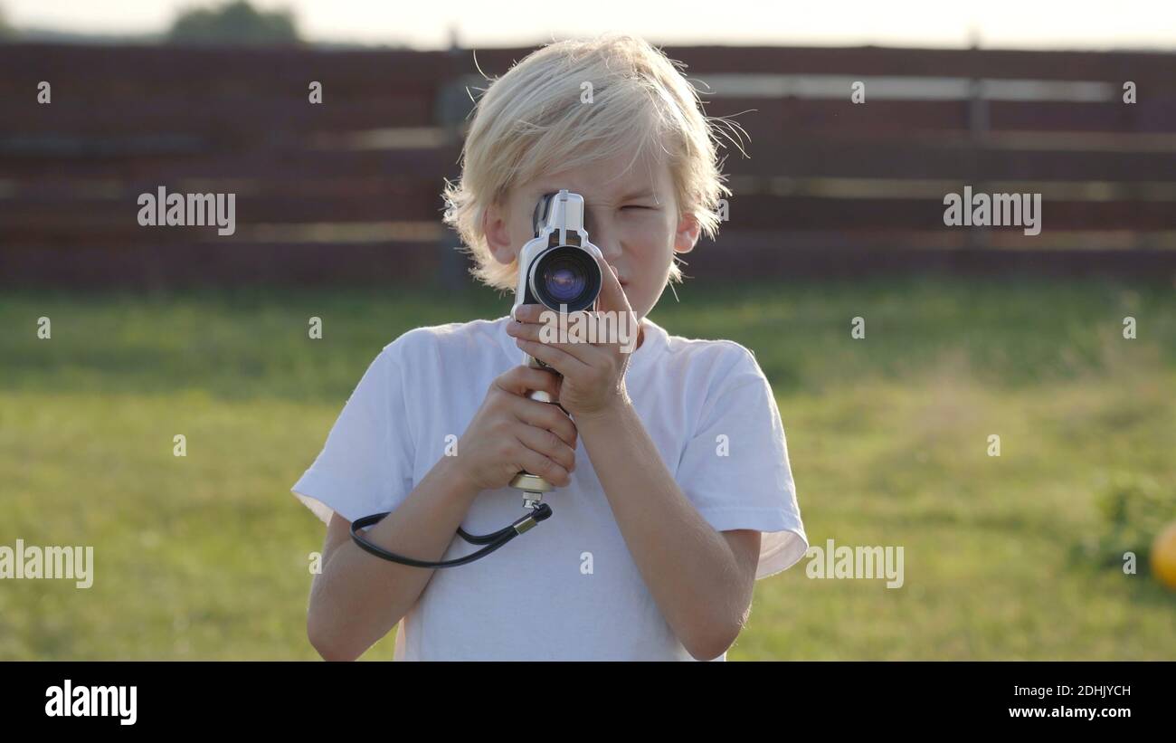 Little boy shoots a video of an old retro camera Stock Photo - Alamy