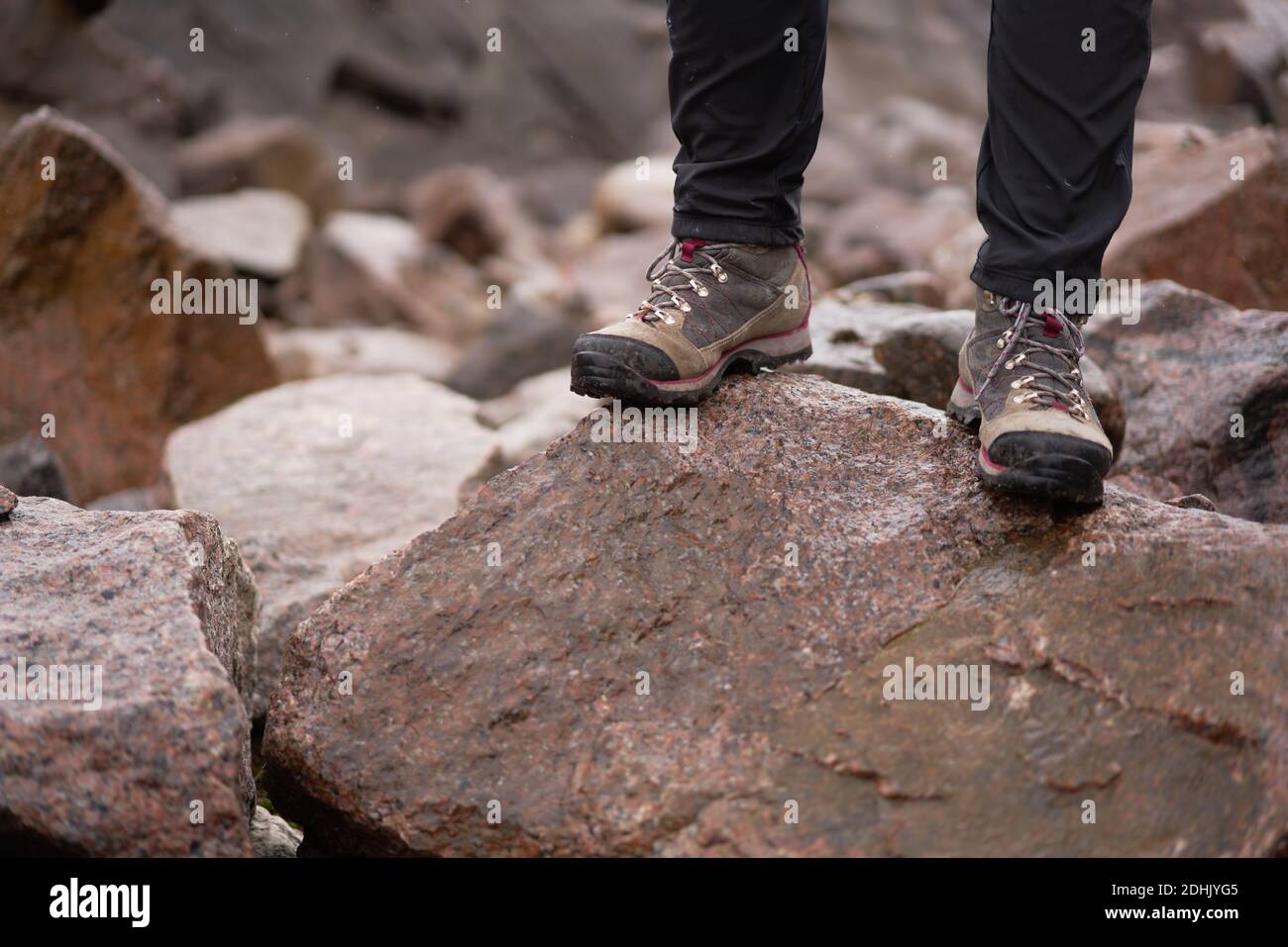 Legs of crop unrecognizable explorer in trekking boots standing on ...