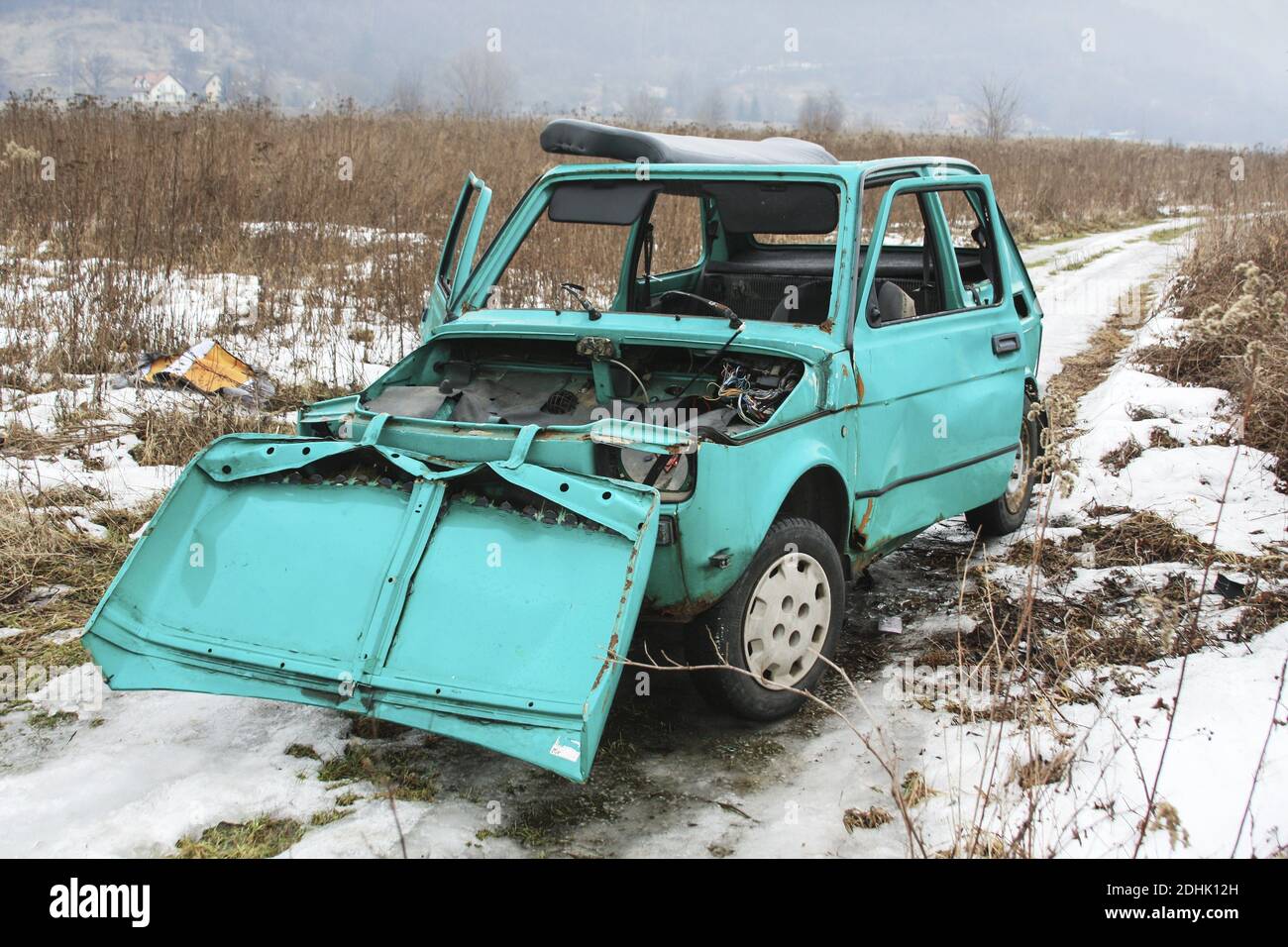 Small car destroyed in an accident on winter country road Stock Photo ...