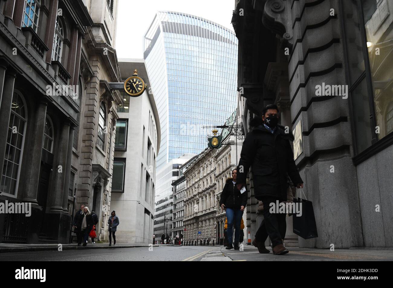 People wearing face masks walk along Lombard Street in the City of ...