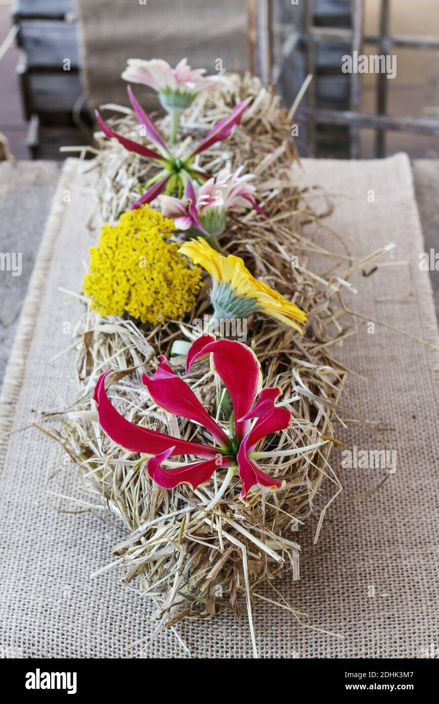 Table decoration with hay and flowers. Rustic style Stock Photo - Alamy