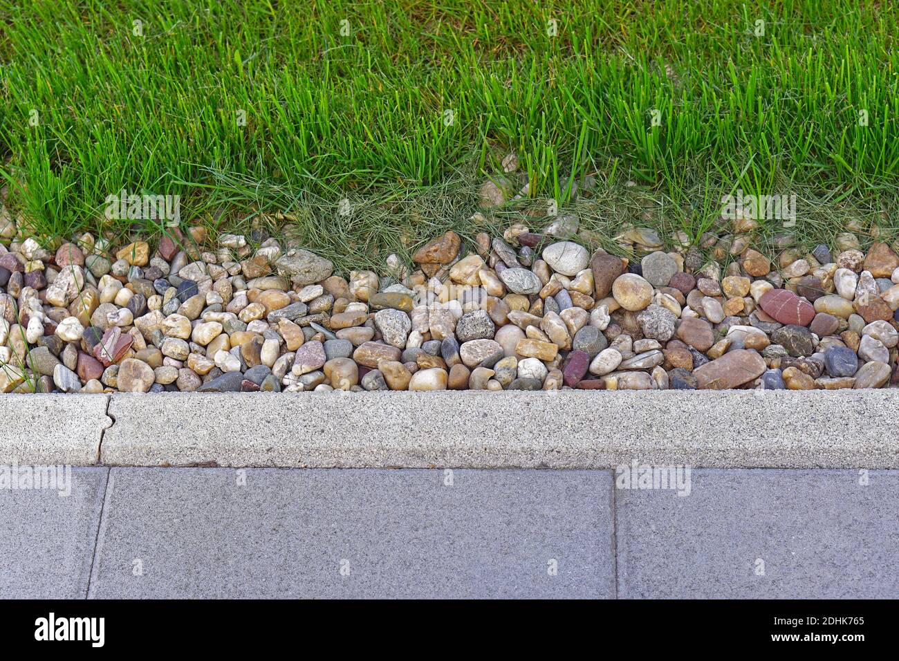 Pebble drain at grass park edge structure Stock Photo - Alamy