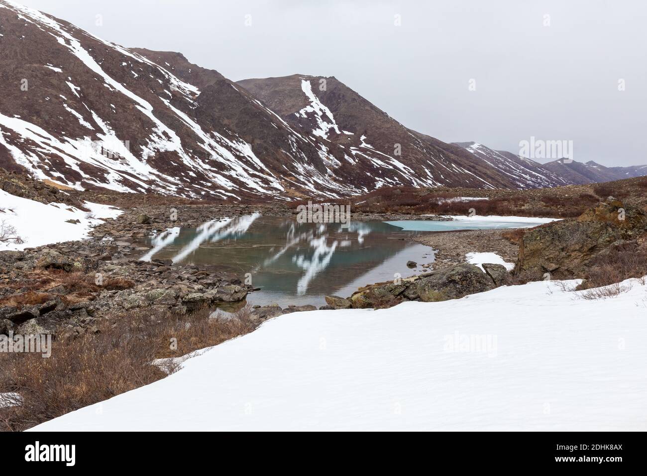 A mesmerizing shot of a mineral water pond and snowy mountains in ...