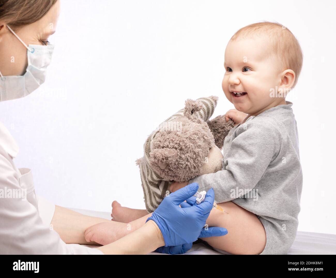 Pediatrician or nurse giving an intramuscular injection of a vaccine to ...