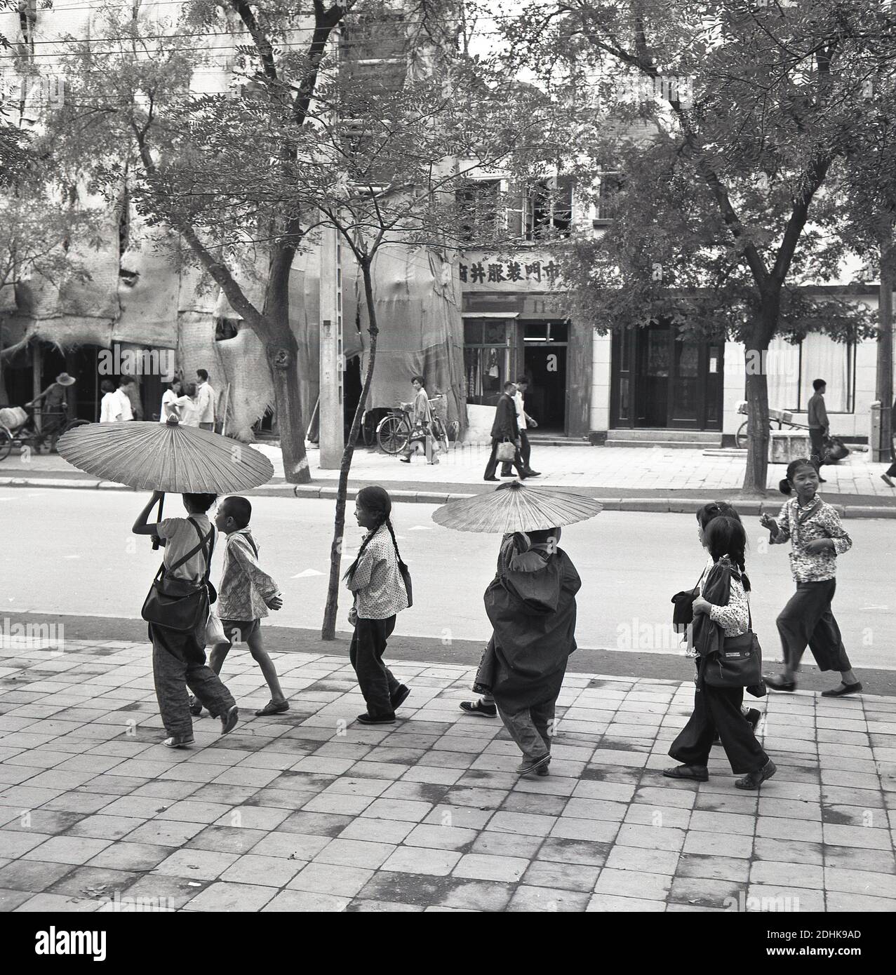 1960s, historical, schoolchildren walking on wide pavement, two holding ...