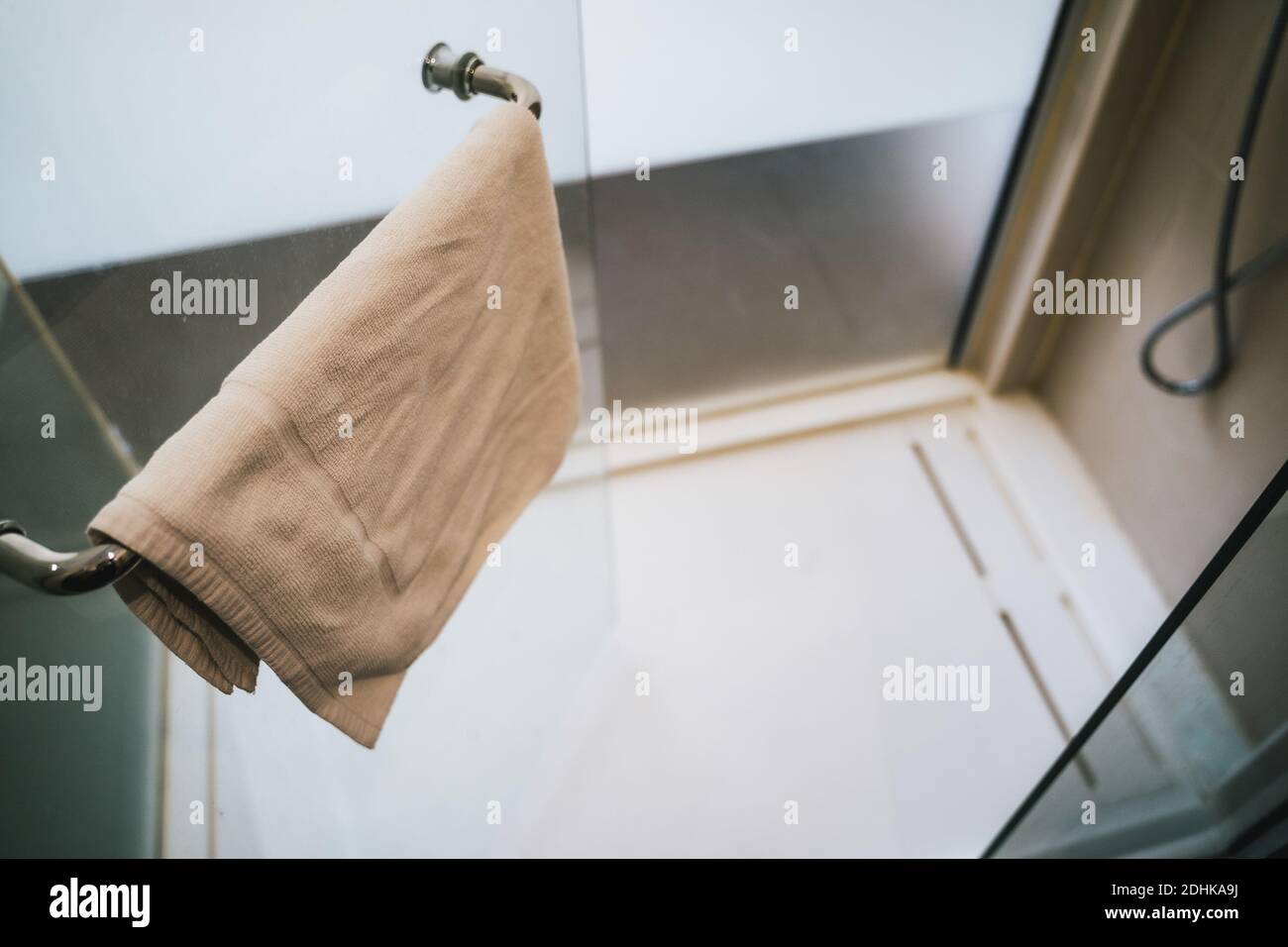 A towel hanging on a handle of a shower tray door Stock Photo - Alamy