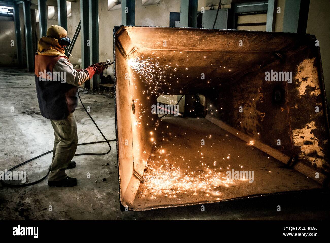 A demolition construction worker with full protective gear using a ...