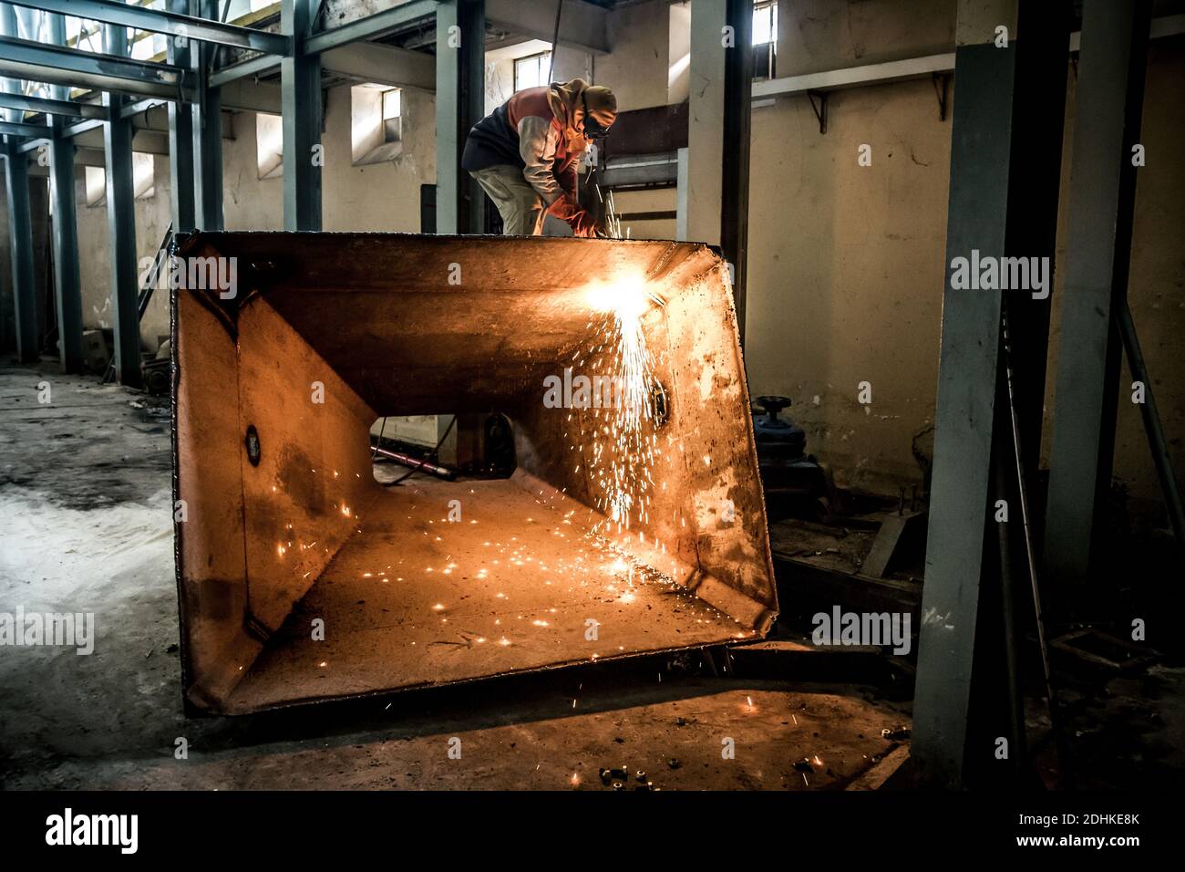 A demolition construction worker with full protective gear using a ...