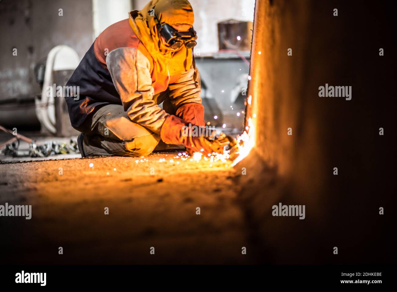 A demolition construction worker with full protective gear using a ...