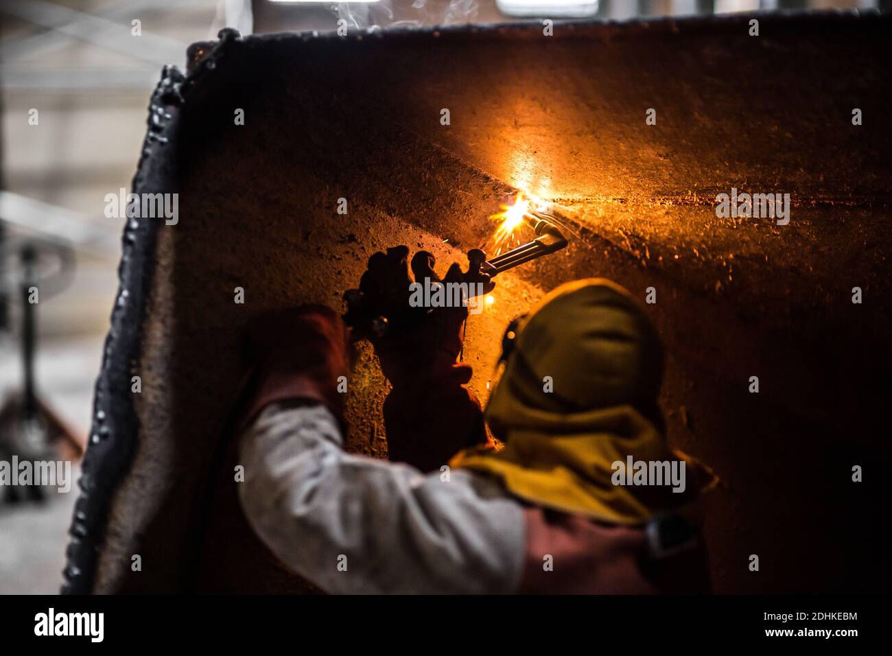 A demolition construction worker with full protective gear using a ...