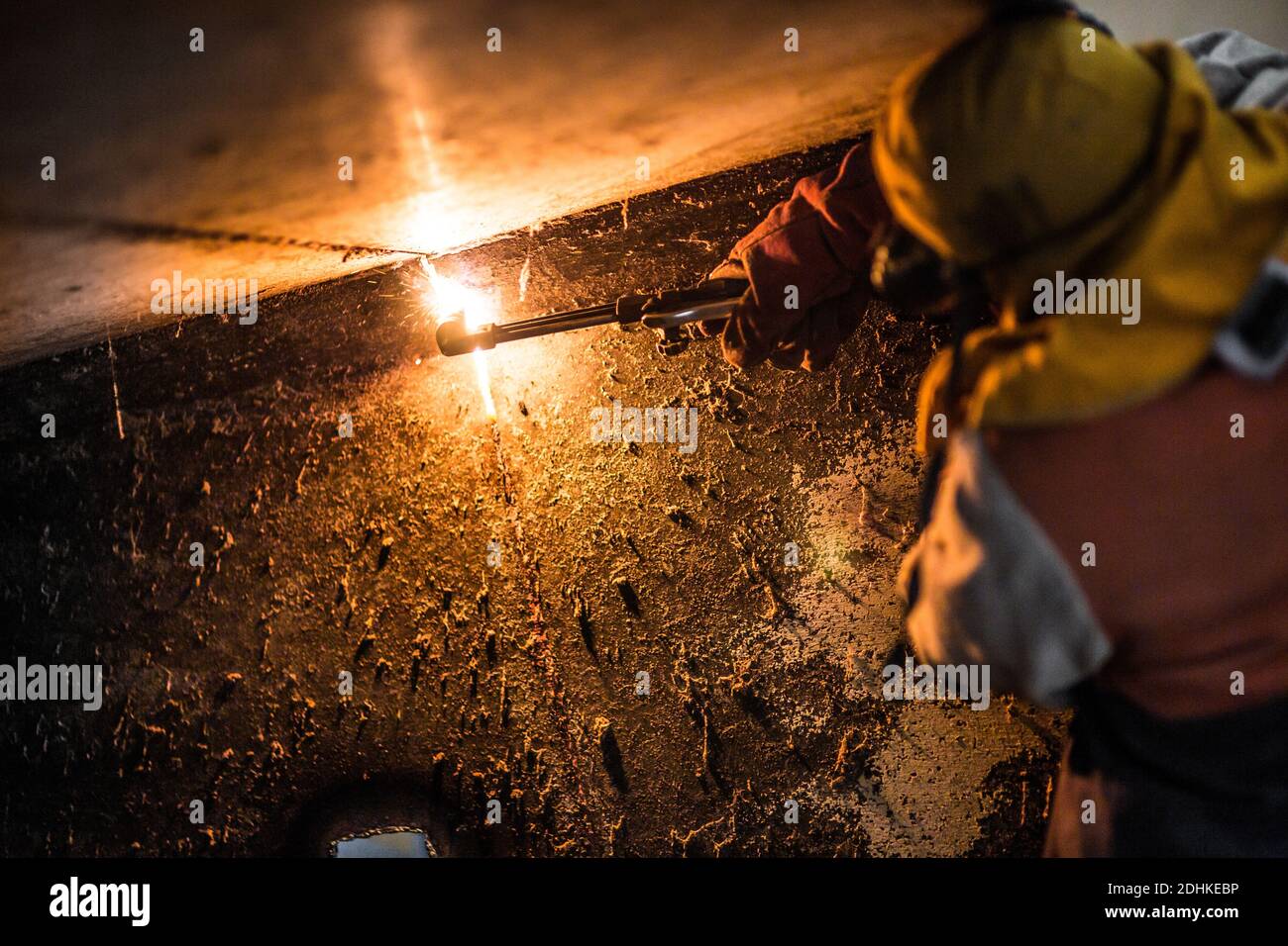 A demolition construction worker with full protective gear using a ...
