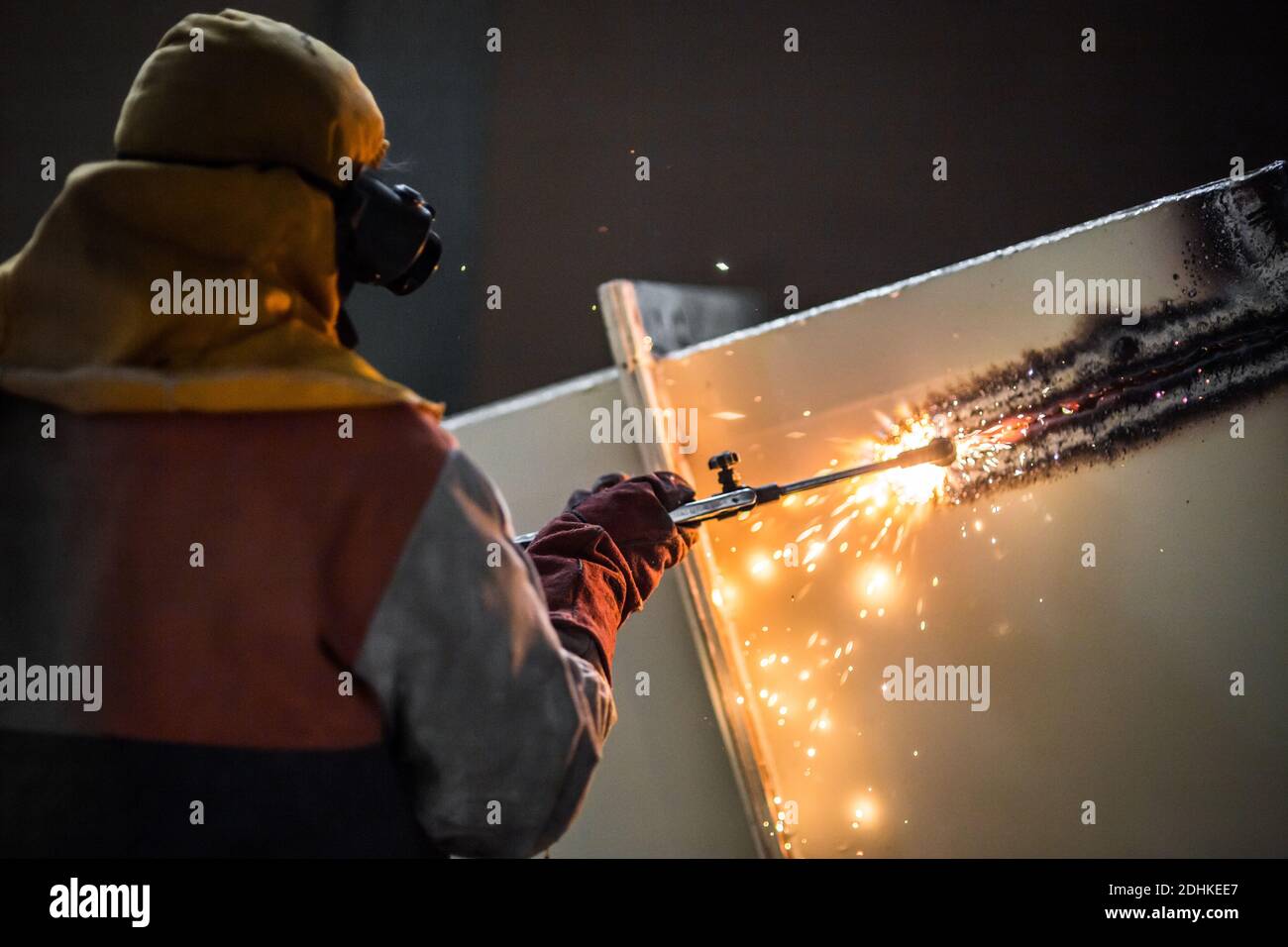 A demolition construction worker with full protective gear using a ...