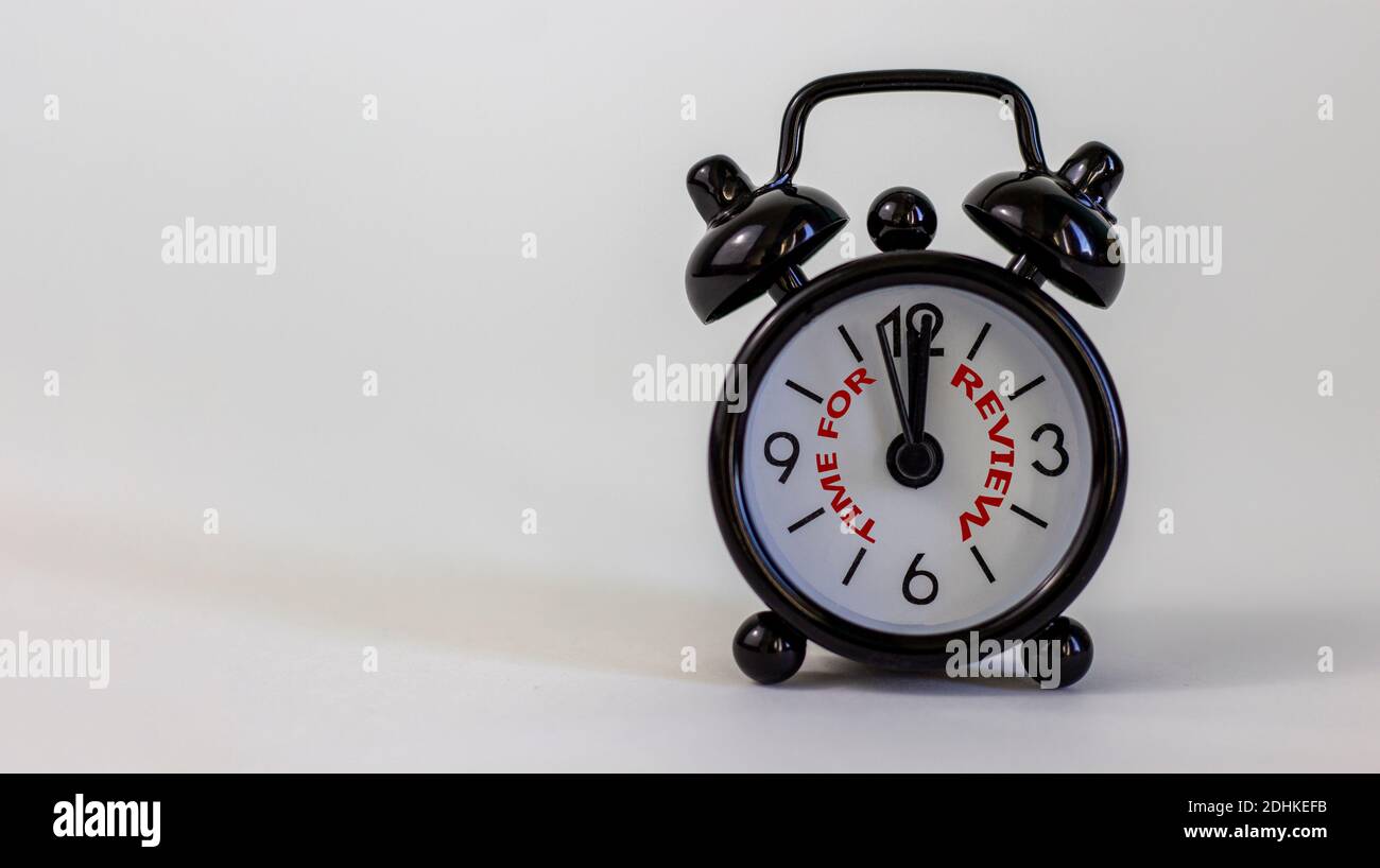 Time to review concept. Beautiful black alarm clock with words 'time to ...