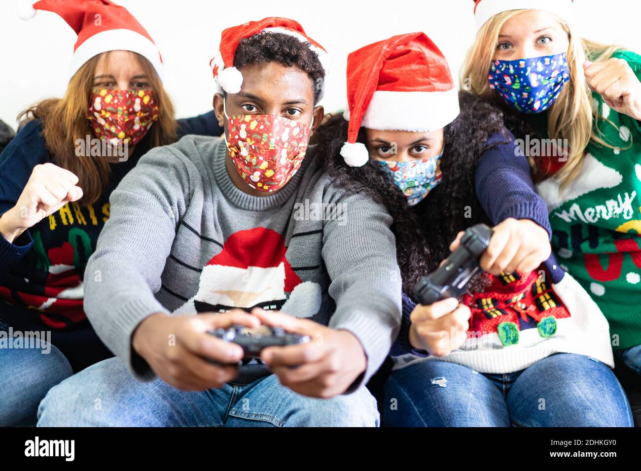 Millennial people having fun with video games console on christmas time ...