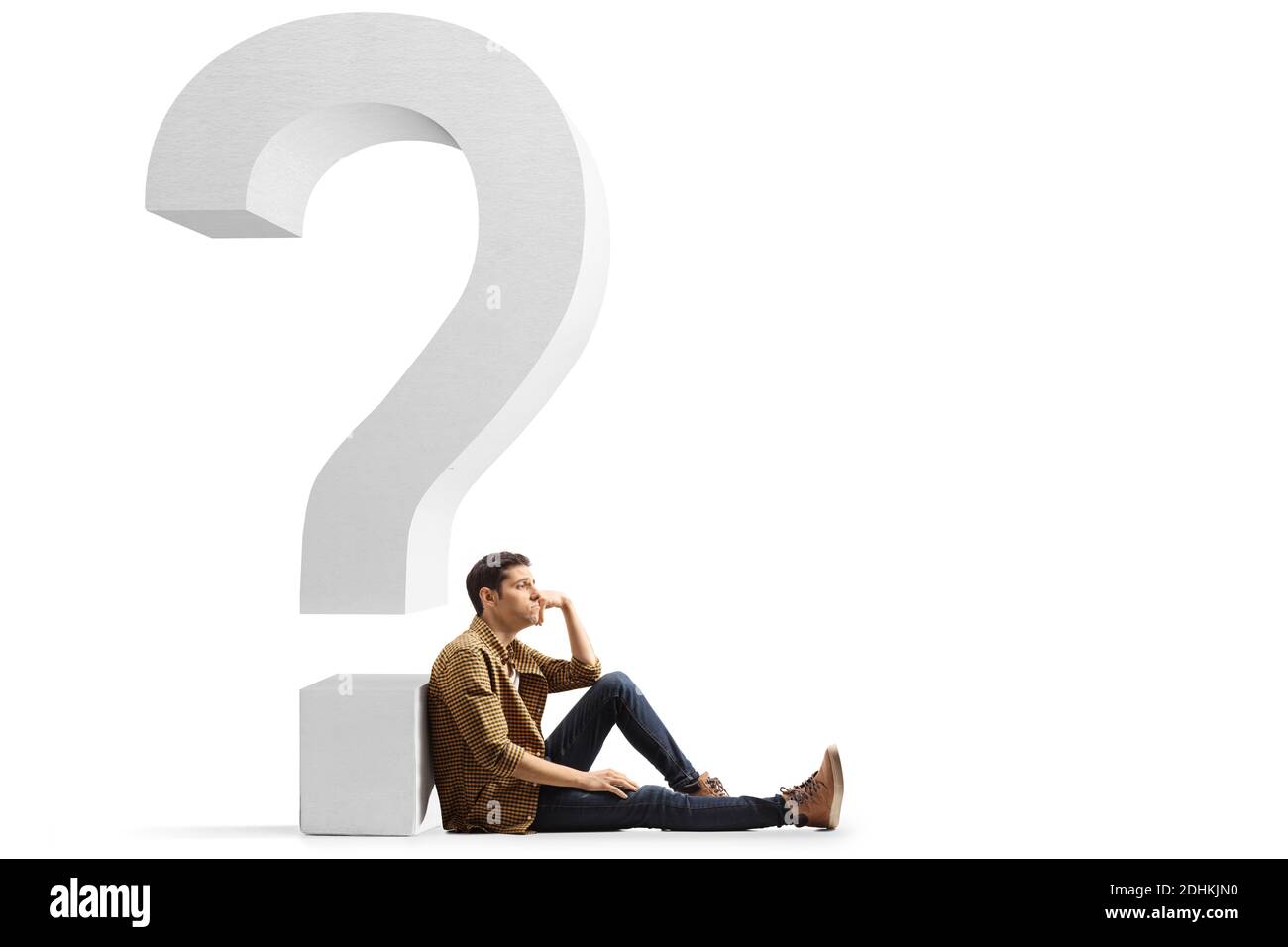 Sad and pensive young man sitting on the floor and leaning on a ...