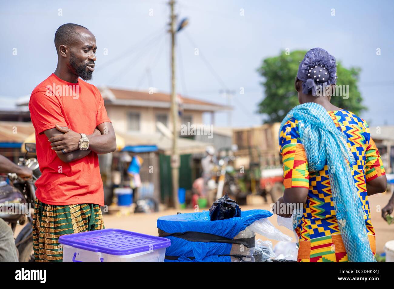 A view of an African man shopping from the outdoor market from a lady ...