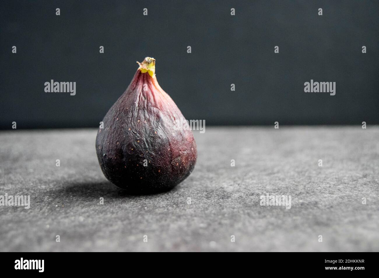 Single over ripe fig against a dark background Stock Photo - Alamy
