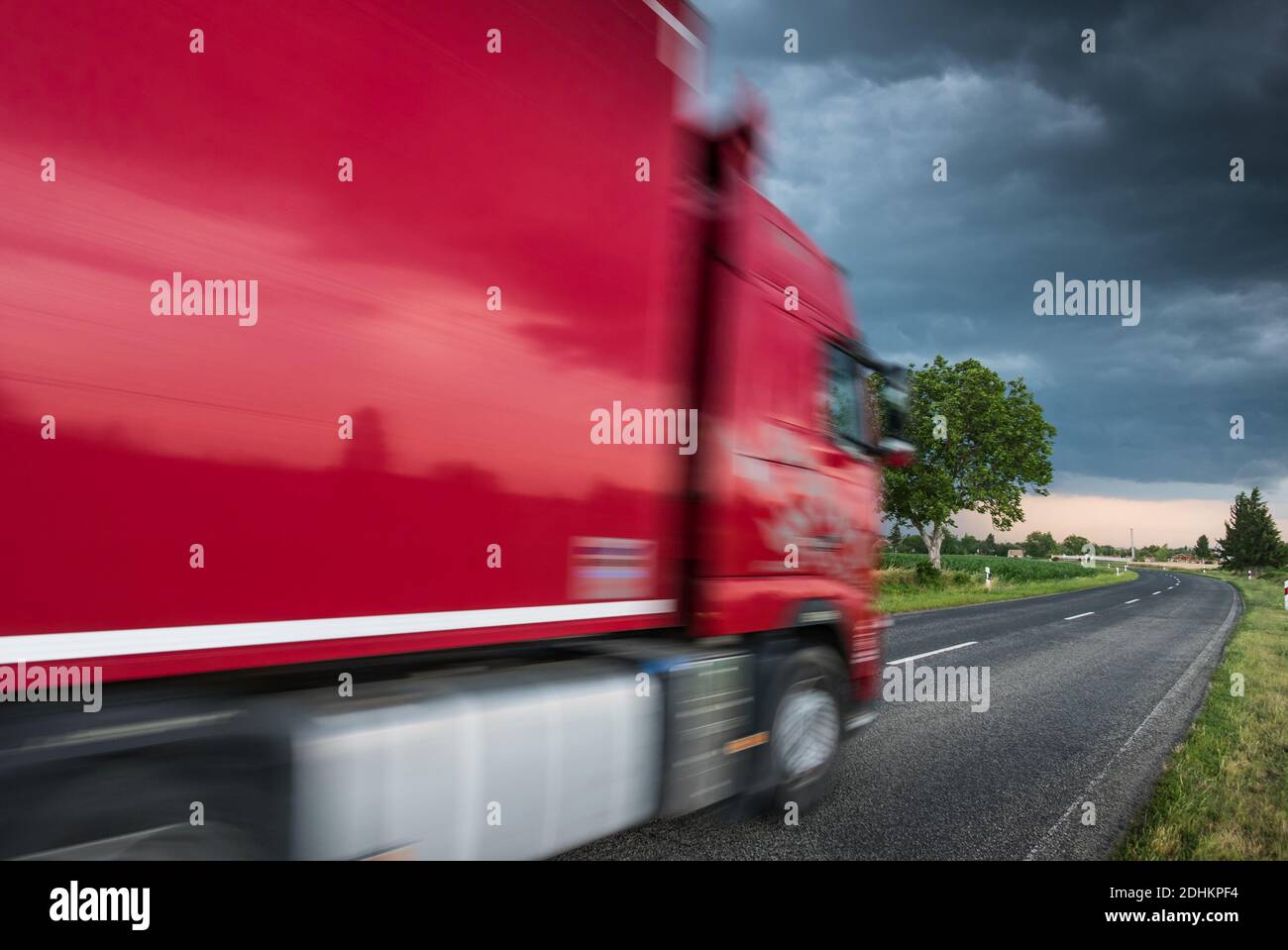 Red truck on asphalt road under stormy sky with clouds Stock Photo - Alamy