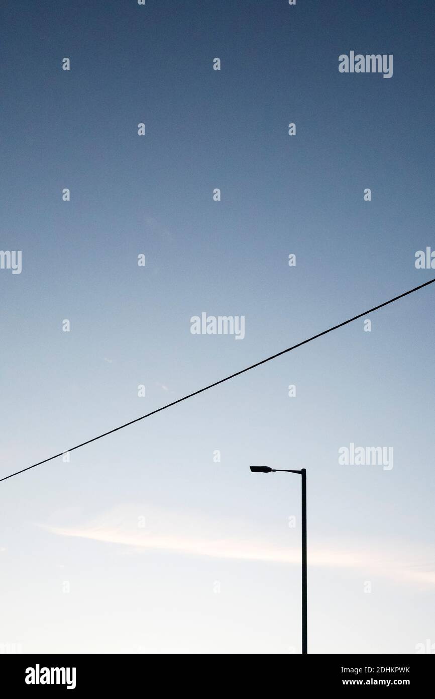 A simple image of a single street lamp and overhead power line Stock ...
